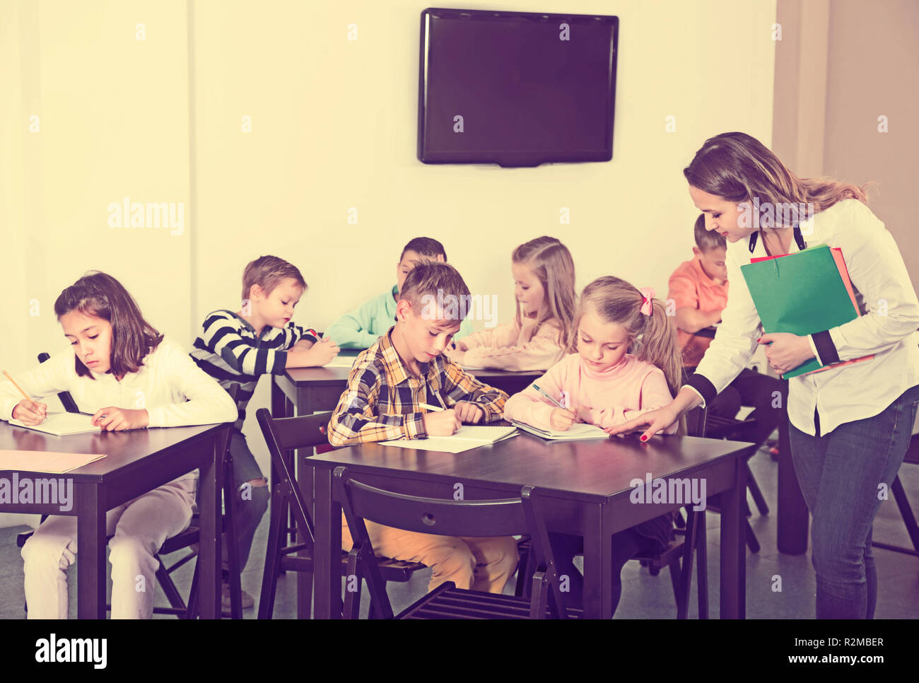 Professor and elementary age children at a classroom in school Stock ...