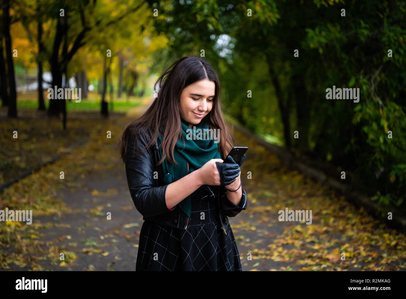 Portrait of a happy young woman reading text message on mobile phone ...