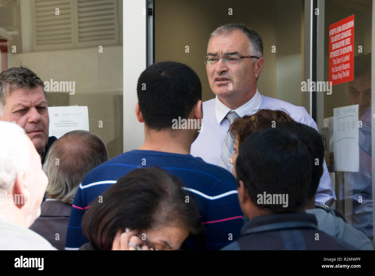 Nicosia, Cyprus 2013. Concerned bank manager addresses concerned crowd ...