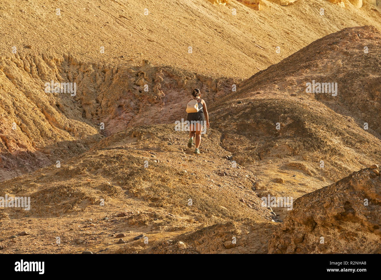 Girl climbing a canyon mountain in the Namibe Desert. Africa. Angola ...
