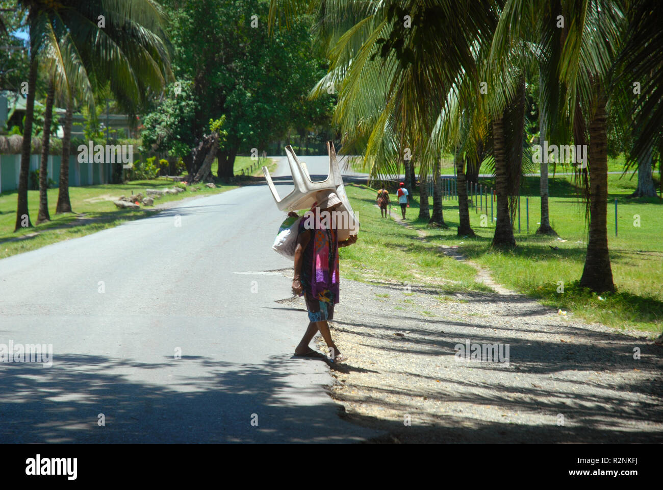 Woman carrying chair on head hi-res stock photography and images - Alamy