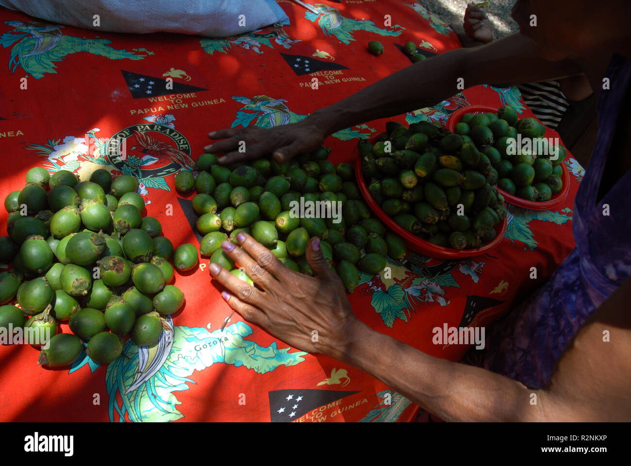 Woman selling betel nut, mustard and lime powder at market in Madang ...