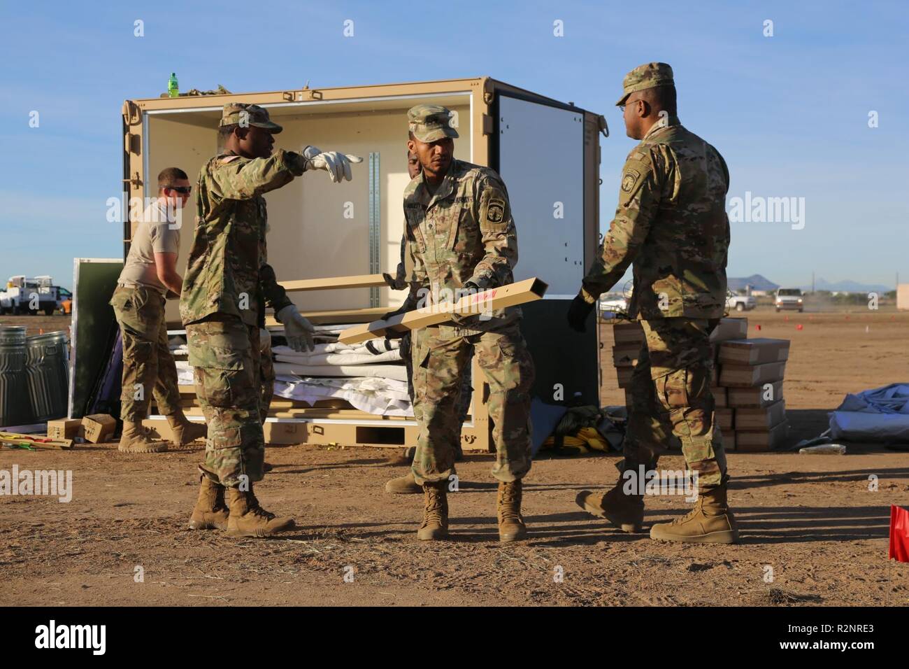 U.S. Soldiers from the 16th MP Brigade unpackage parts of a tent from a ...