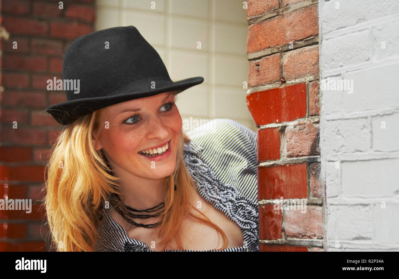 Girl peeking around wall looking hi-res stock photography and images ...