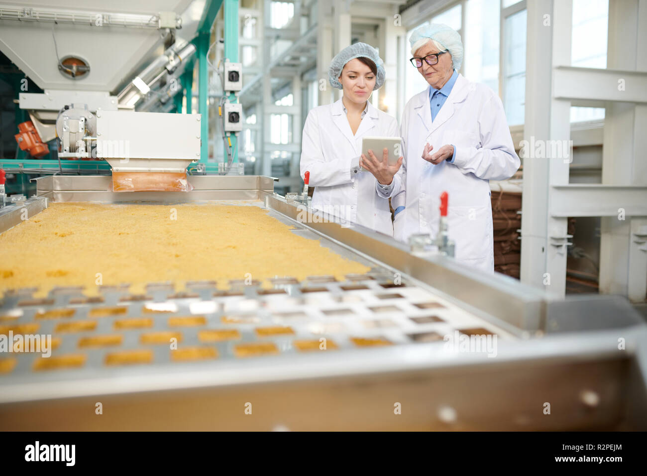 Two Workers Overseeing Food Production Stock Photo - Alamy