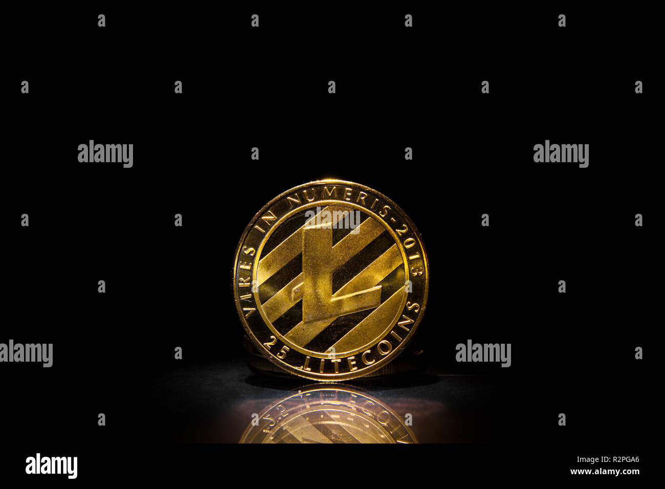 Litecoin (LTC) token, standing upright on a reflective black background ...