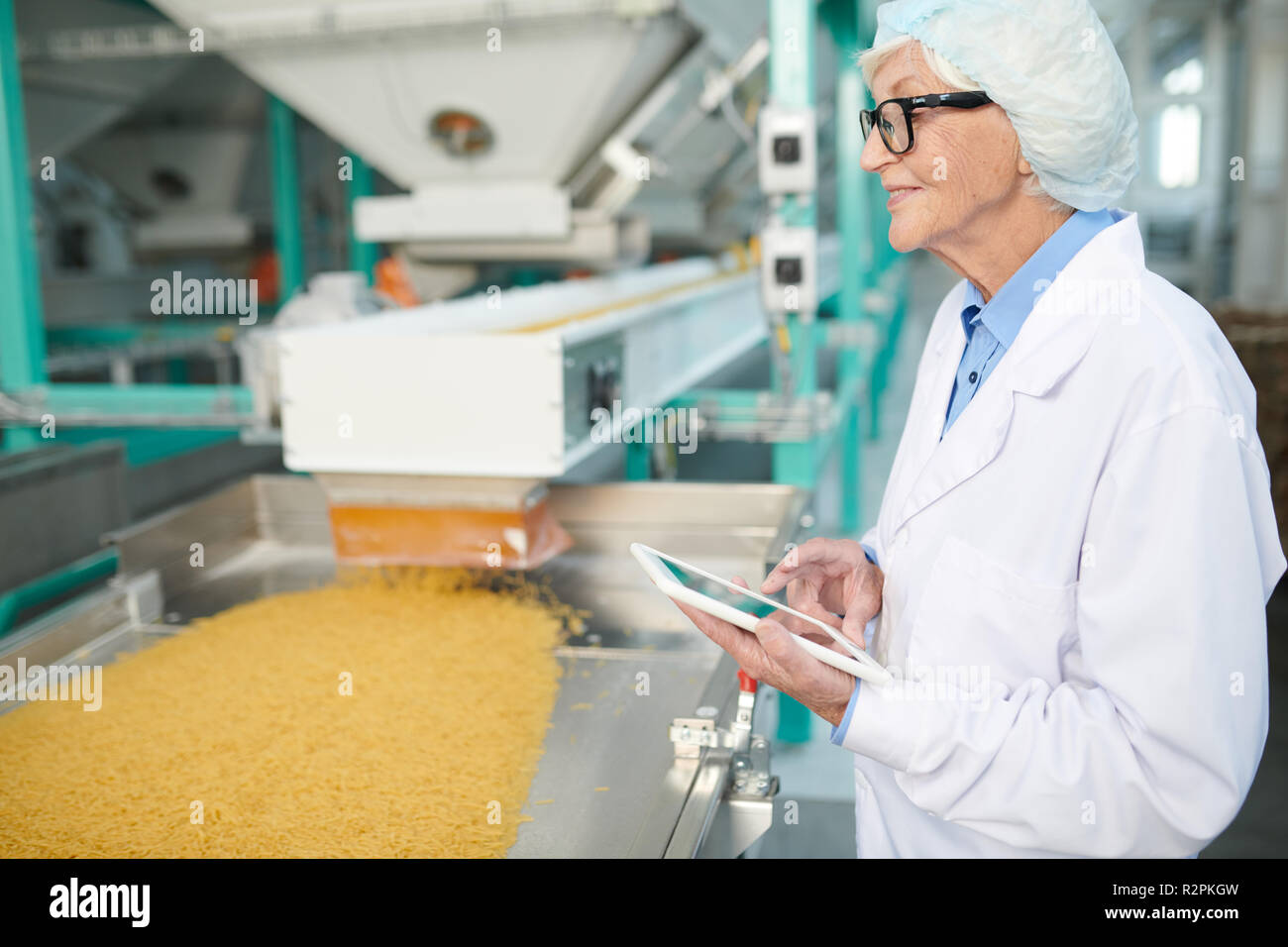 Senior Woman Enjoying Work at Factory Stock Photo - Alamy