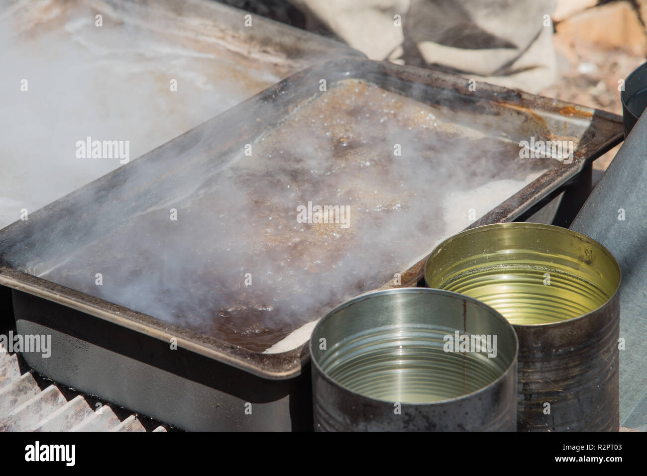 Closeup of boiling maple tree sap in a metal pan being cooked on an ...
