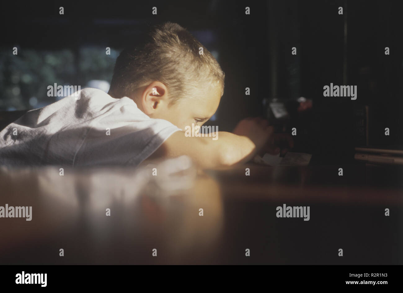 Boy resting on table Stock Photo - Alamy