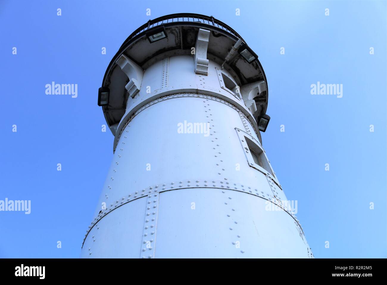 Beautiful low angle shot of a high rise lighthouse on the coast near a ...
