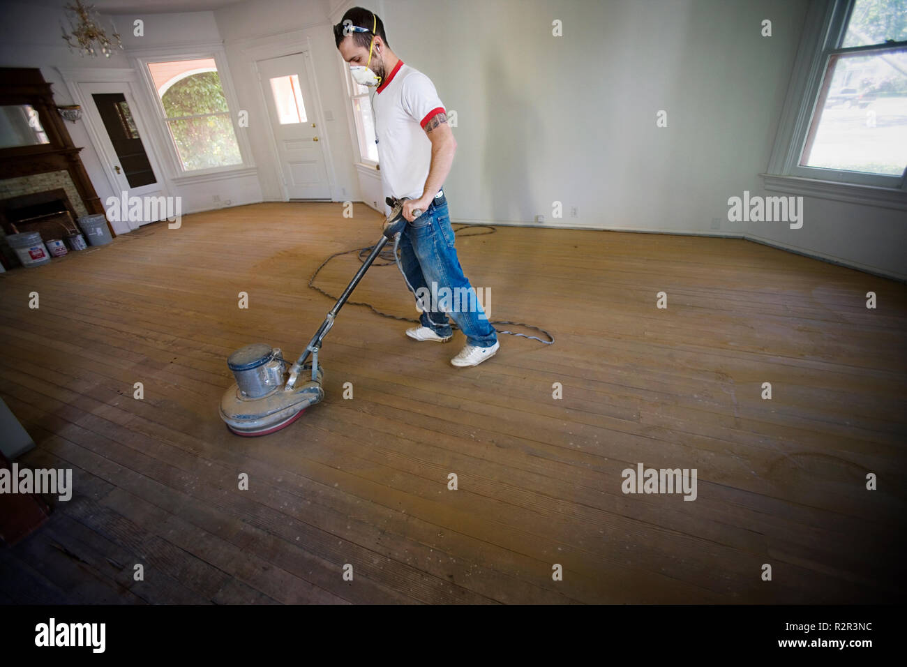 Male builder buffing floorboards inside a room Stock Photo - Alamy