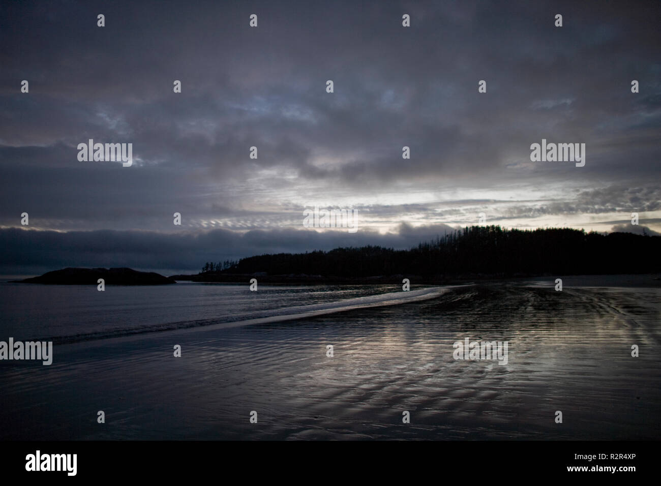 Tide going out at the beach at twilight Stock Photo - Alamy