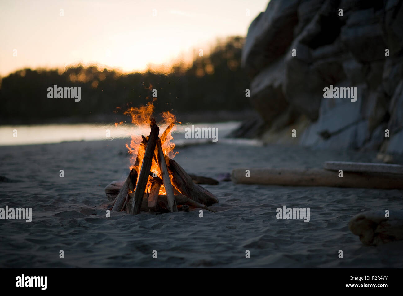 Bonfire on a beach at sunset Stock Photo - Alamy