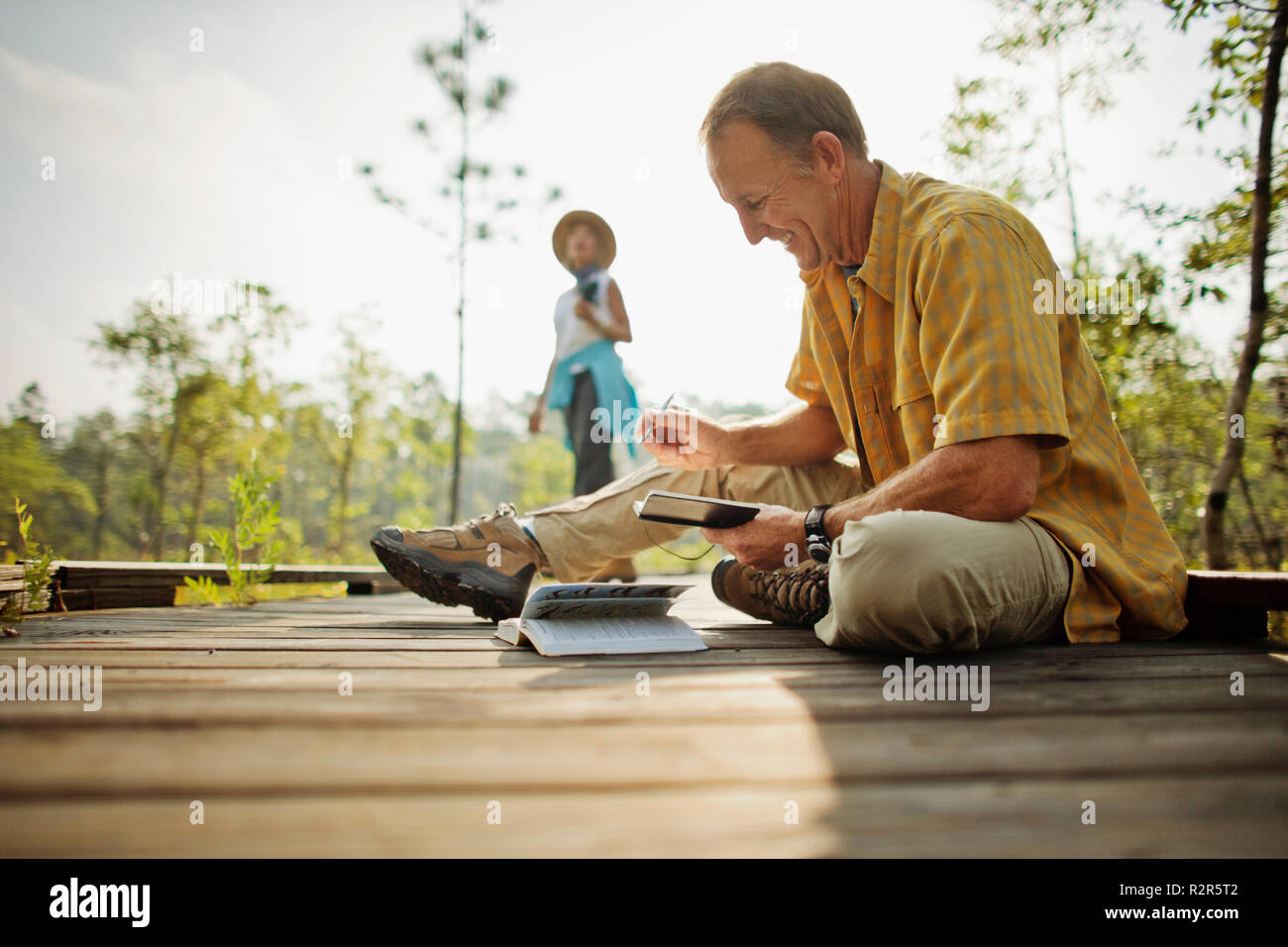 Happy mature couple birdwatching in woodland Stock Photo - Alamy