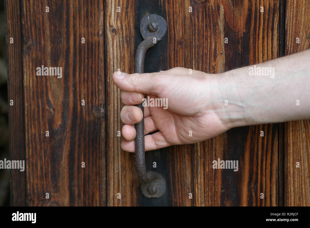 hand on door handle pulls on gate Stock Photo - Alamy