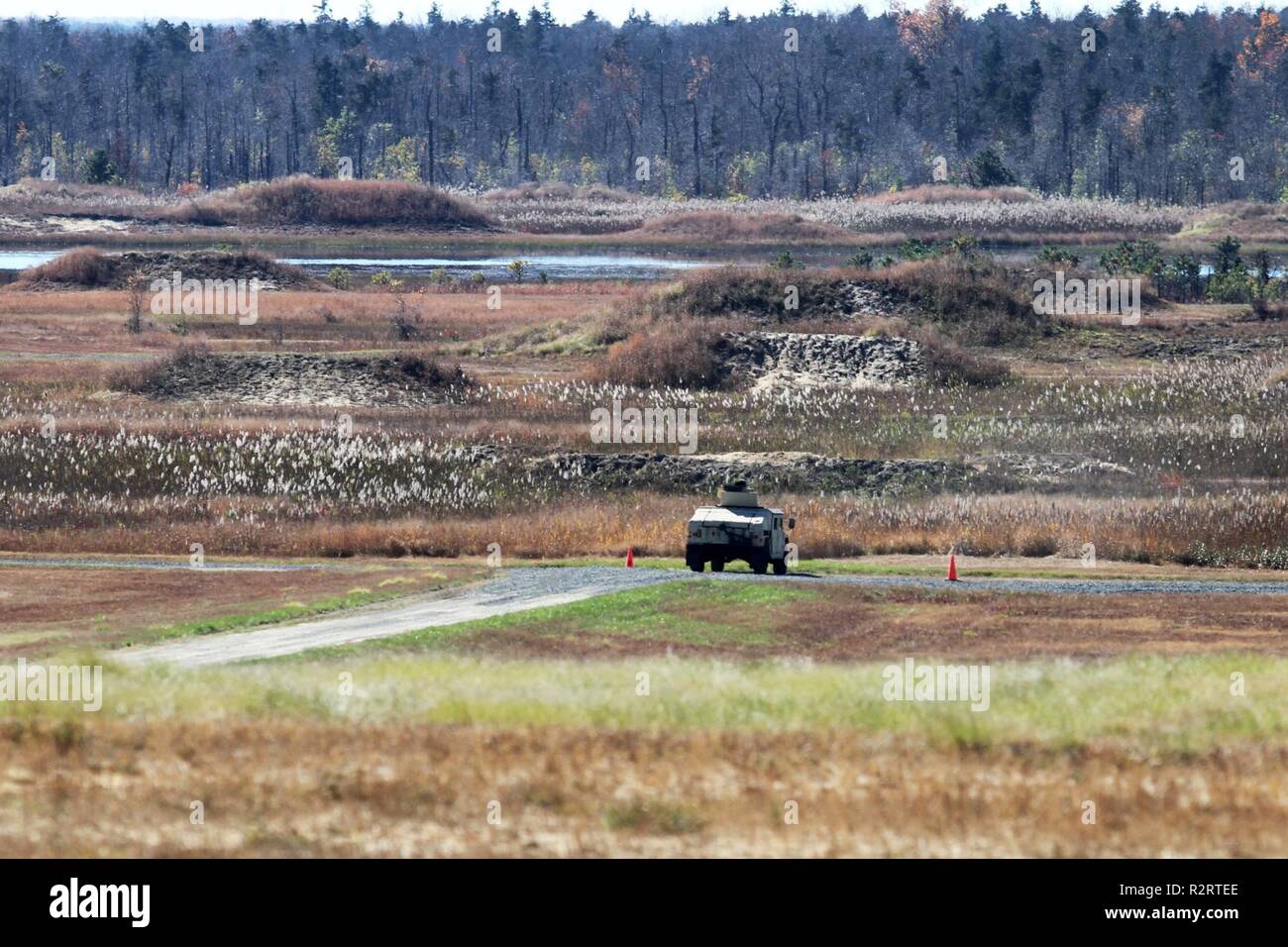 A M1097 HMMWV is staged in the distance while the three-person crew ...