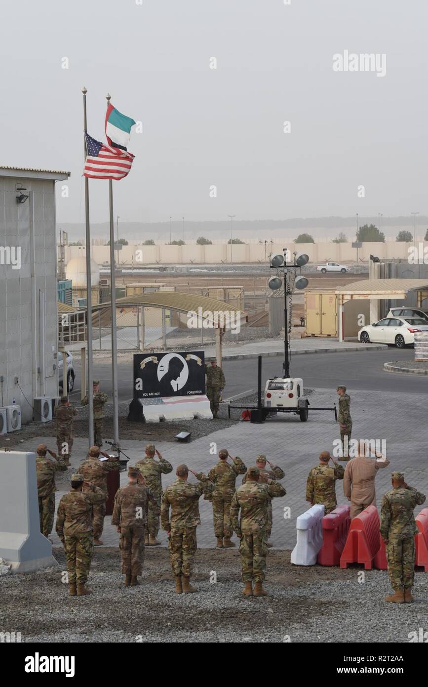 U.S. Airmen salute as the American flag is lowered during a monthly ...