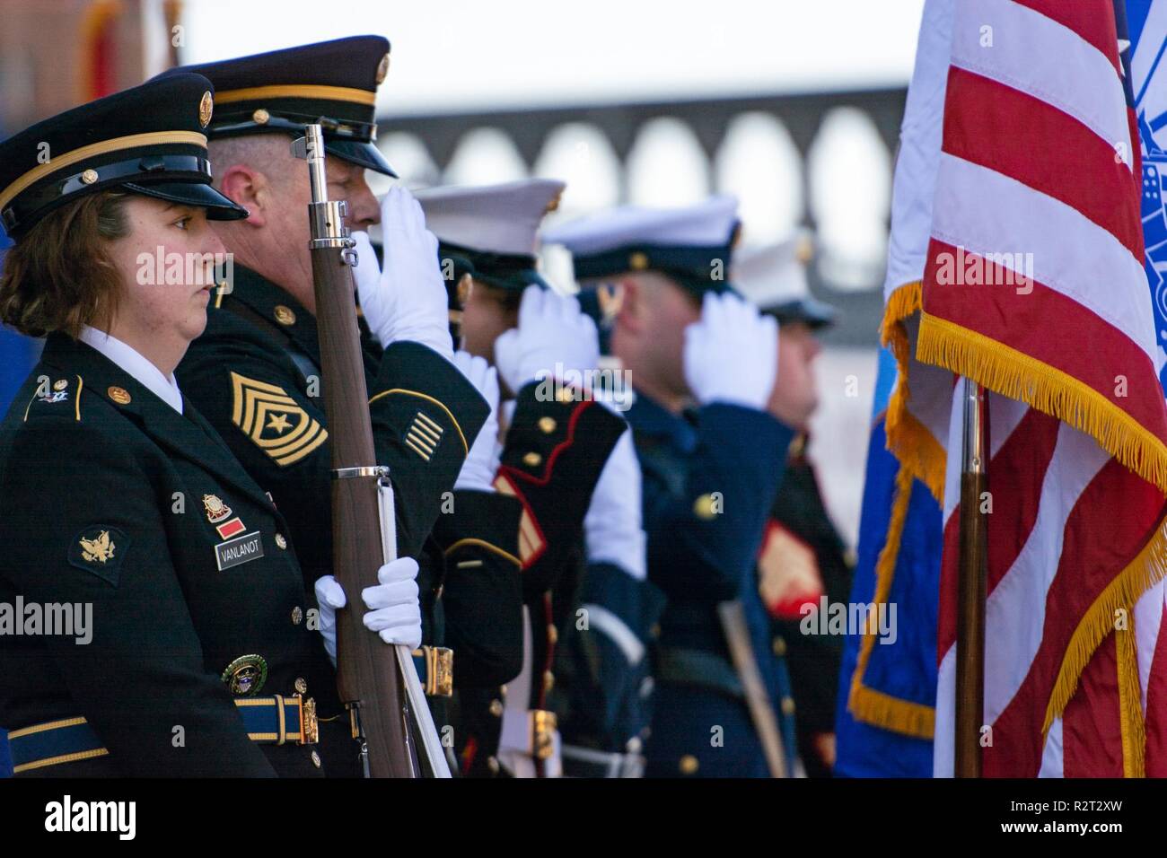 Members of a joint service color guard salute the colors during a ...