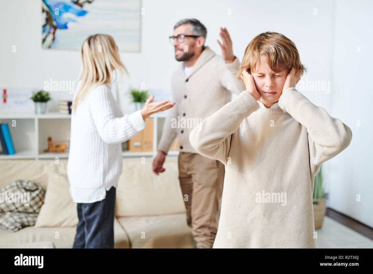 Distraught son suffering from parents conflict Stock Photo - Alamy