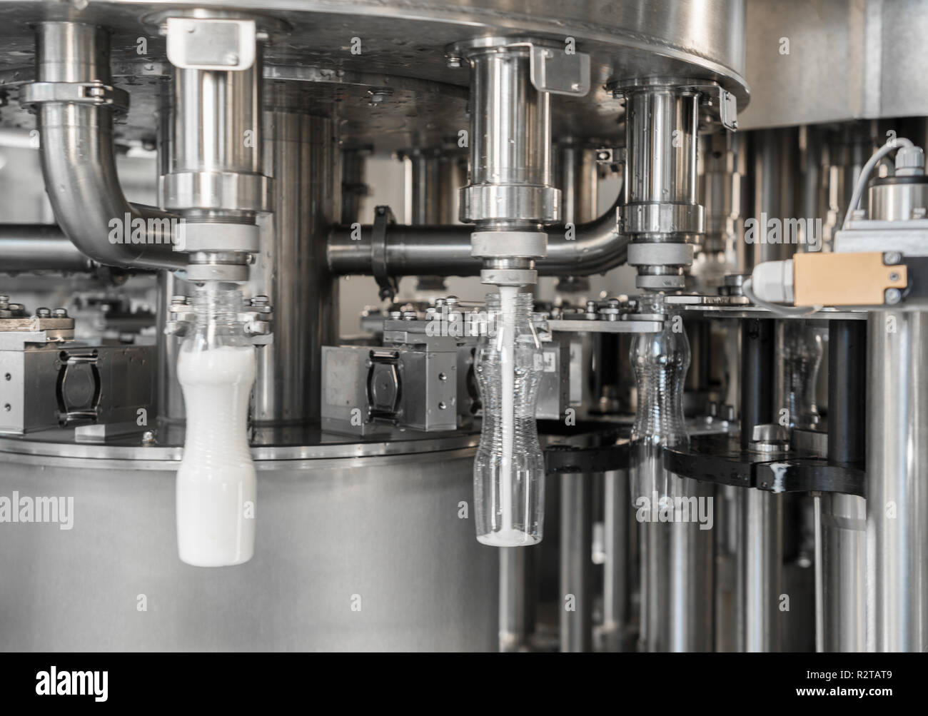 filling milk in to plastic bottles at the factory. equipment at the ...