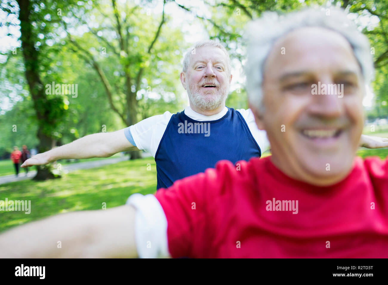 Active senior men exercising, stretching in park Stock Photo - Alamy