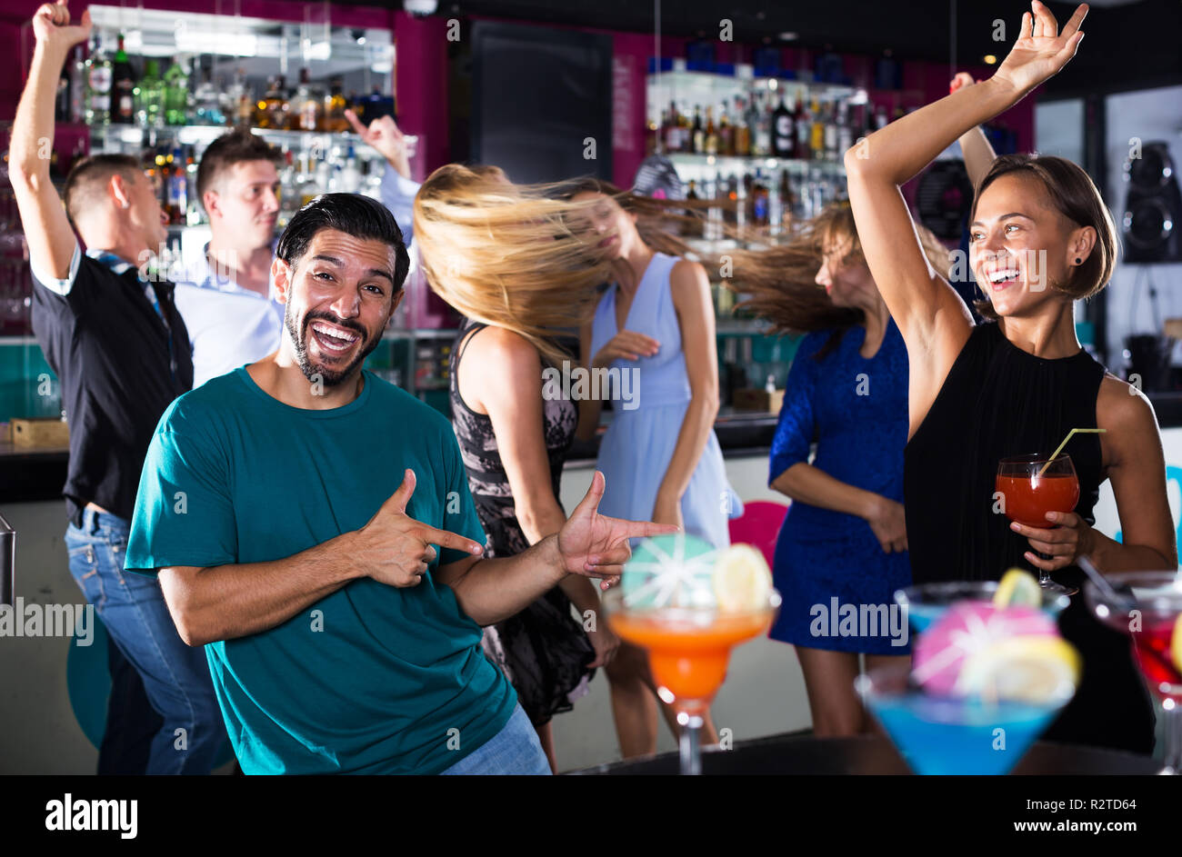 Female with man are dancing and drinking cocktail on the party in ...