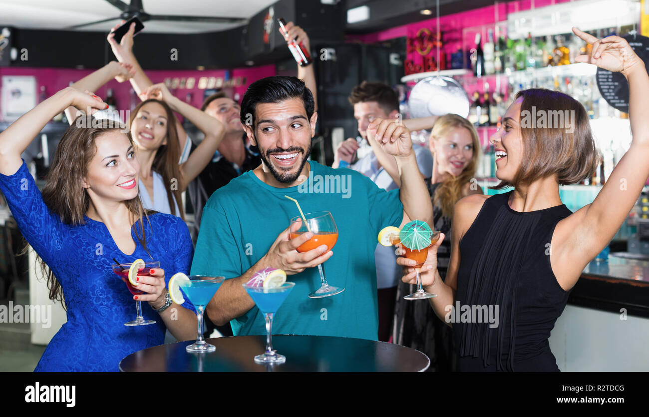 Man with two women are drinking cocktails on corporate party Stock ...