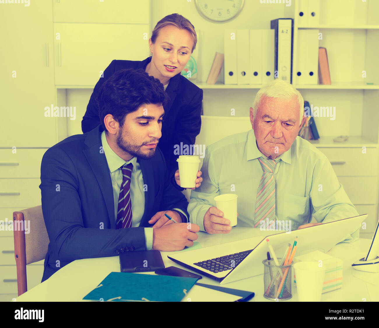 Managers are demonstrating reports on laptop to mature boss in the ...