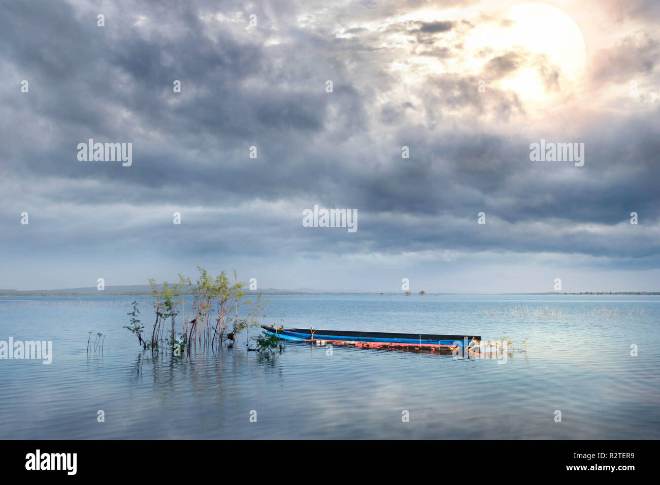 The boat in lake under beautiful rain clouds and sun Stock Photo - Alamy