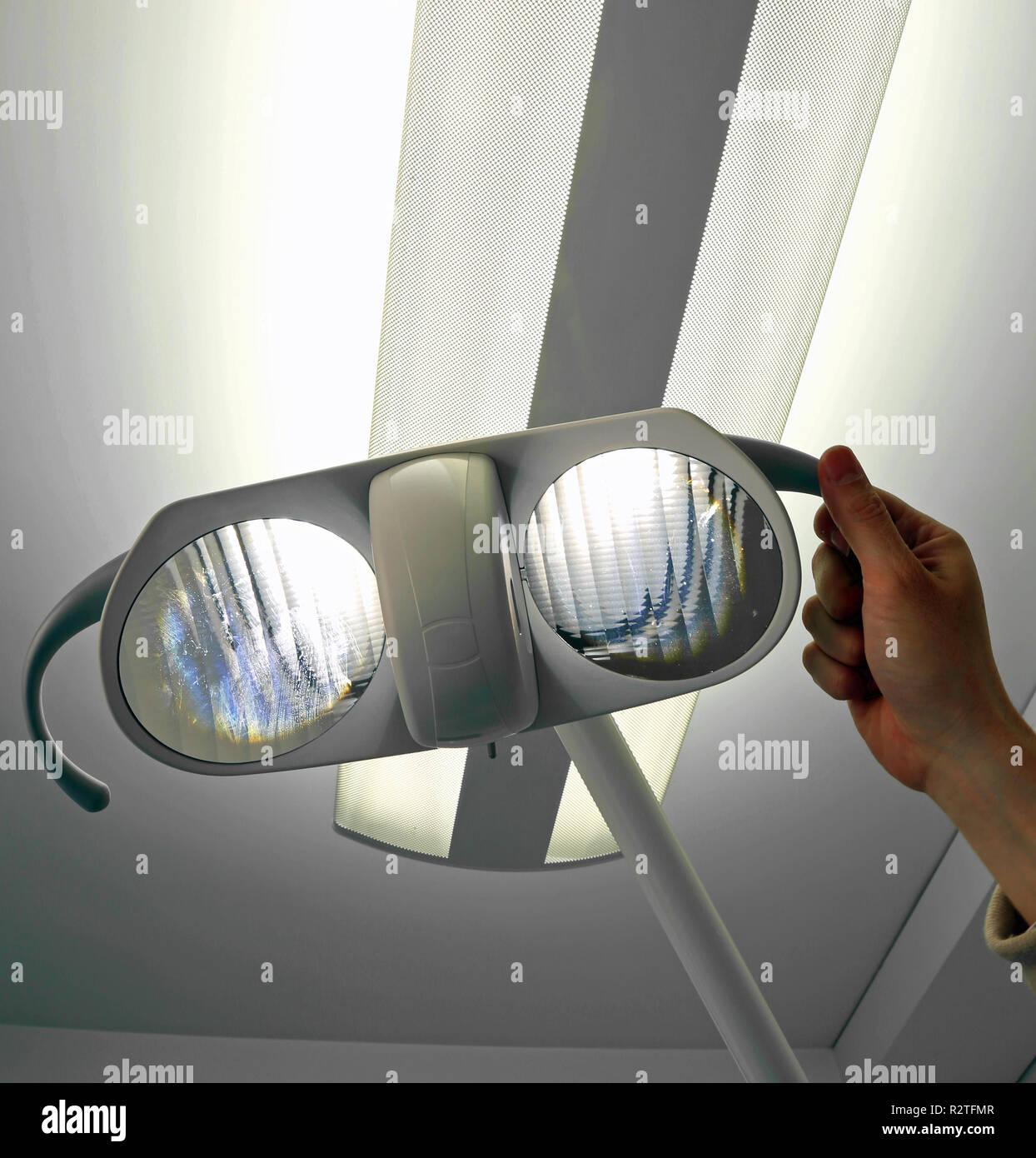lamp of an operating room and the hand of the doctor adjusting the ...
