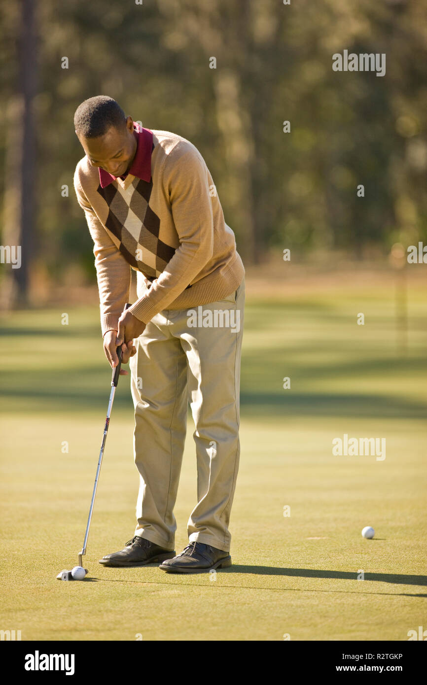 Man putting golf ball Stock Photo - Alamy