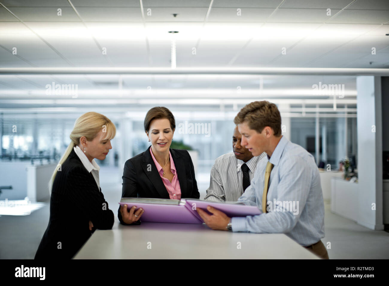 Office workers looking at files together Stock Photo - Alamy