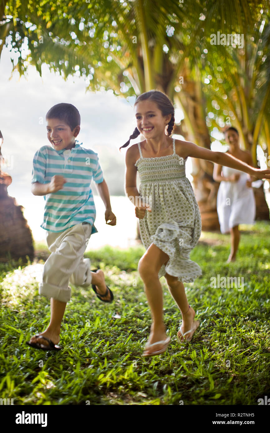 Brother and sister running on lawn together Stock Photo - Alamy