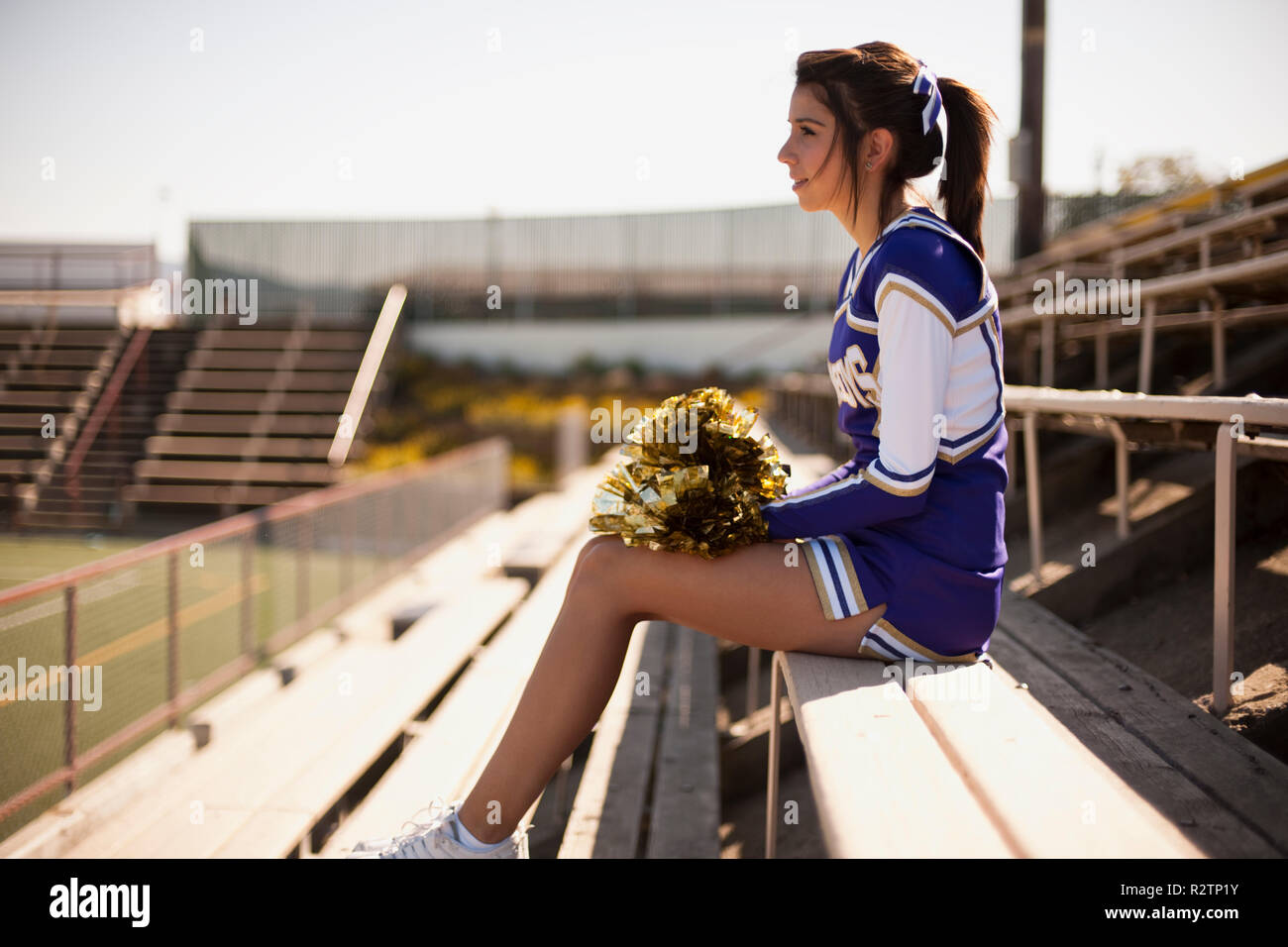 Cheerleader sitting in sports stadium looking across the field Stock ...