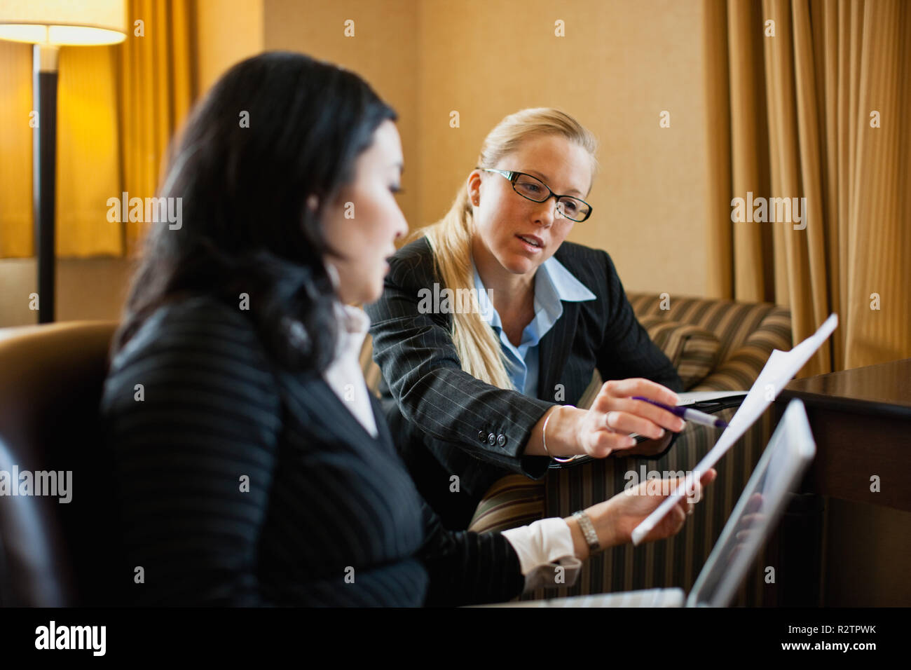 Two female colleagues discussing business in their hotel room Stock ...