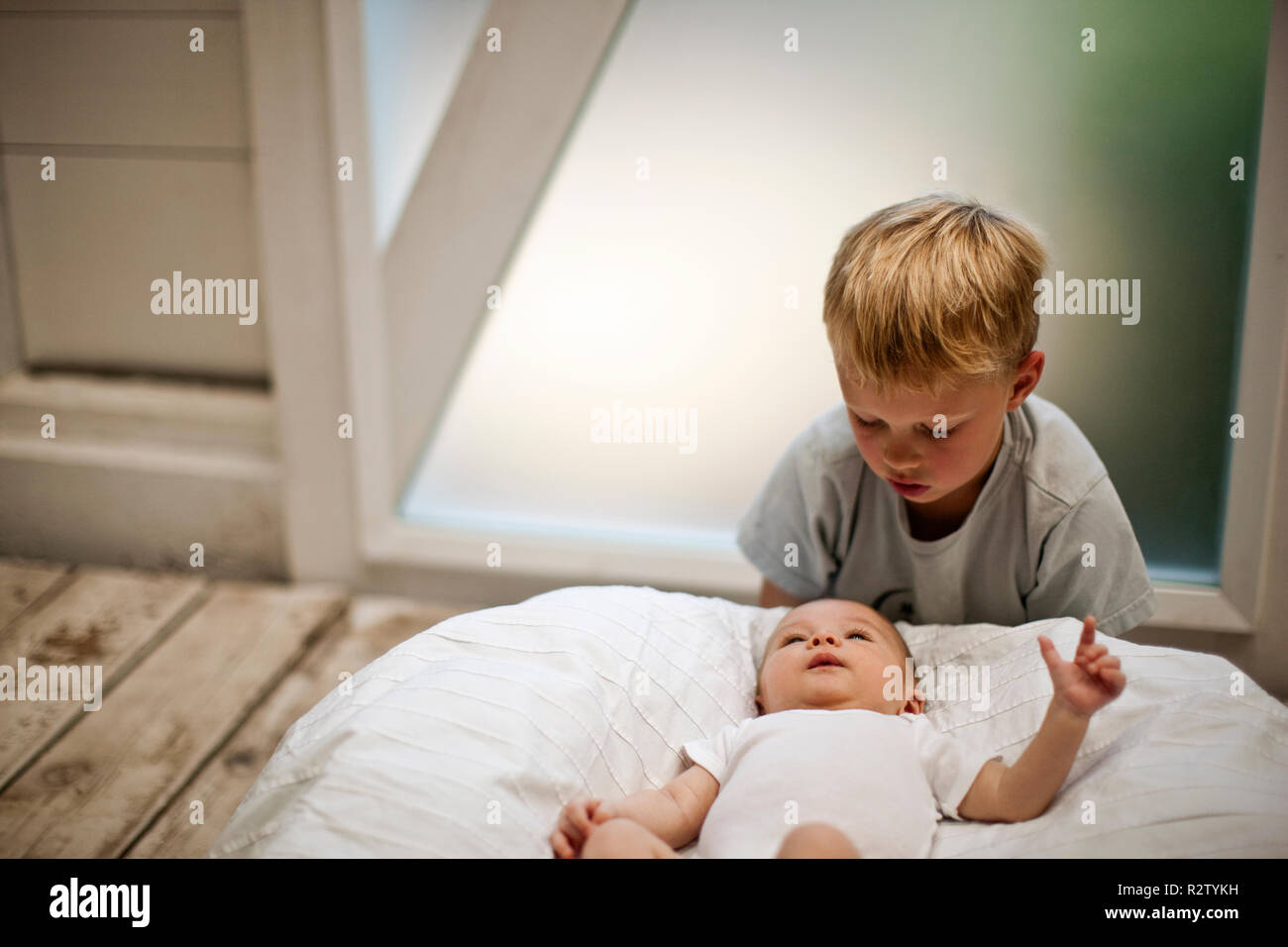 Boy looking curiously newborn baby hi-res stock photography and images ...