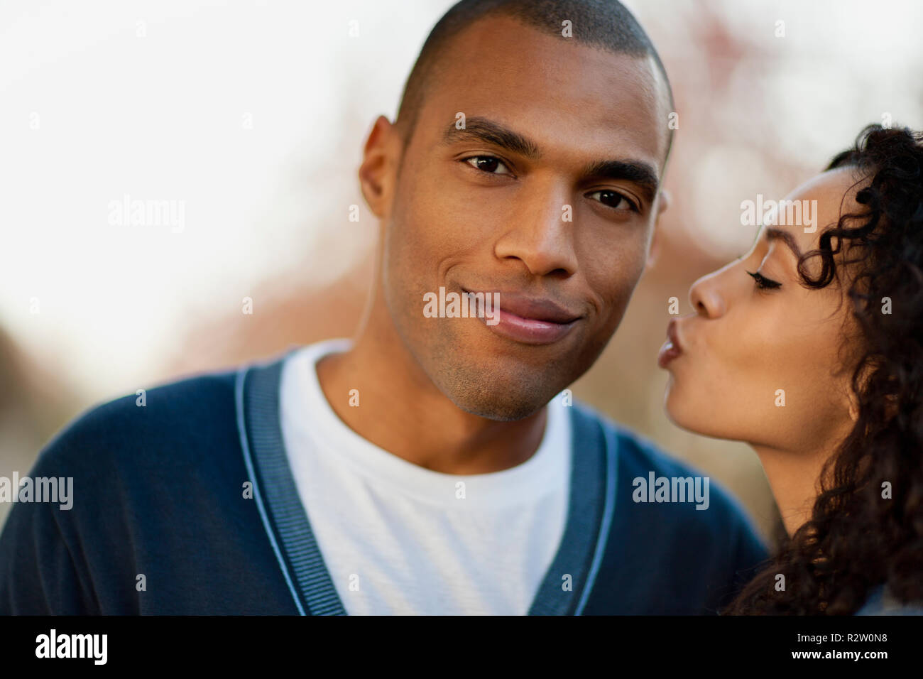 Mid-adult man being kissed on the cheek by his girlfriend Stock Photo ...