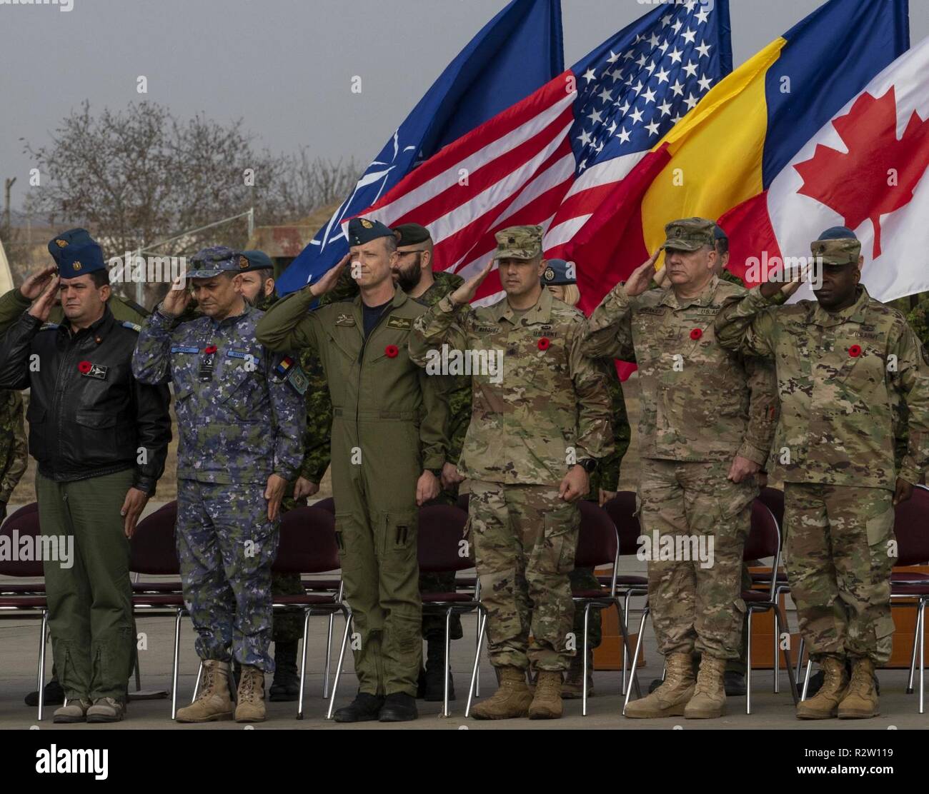 The honor party salutes during national anthems at a Remembrance Day ...