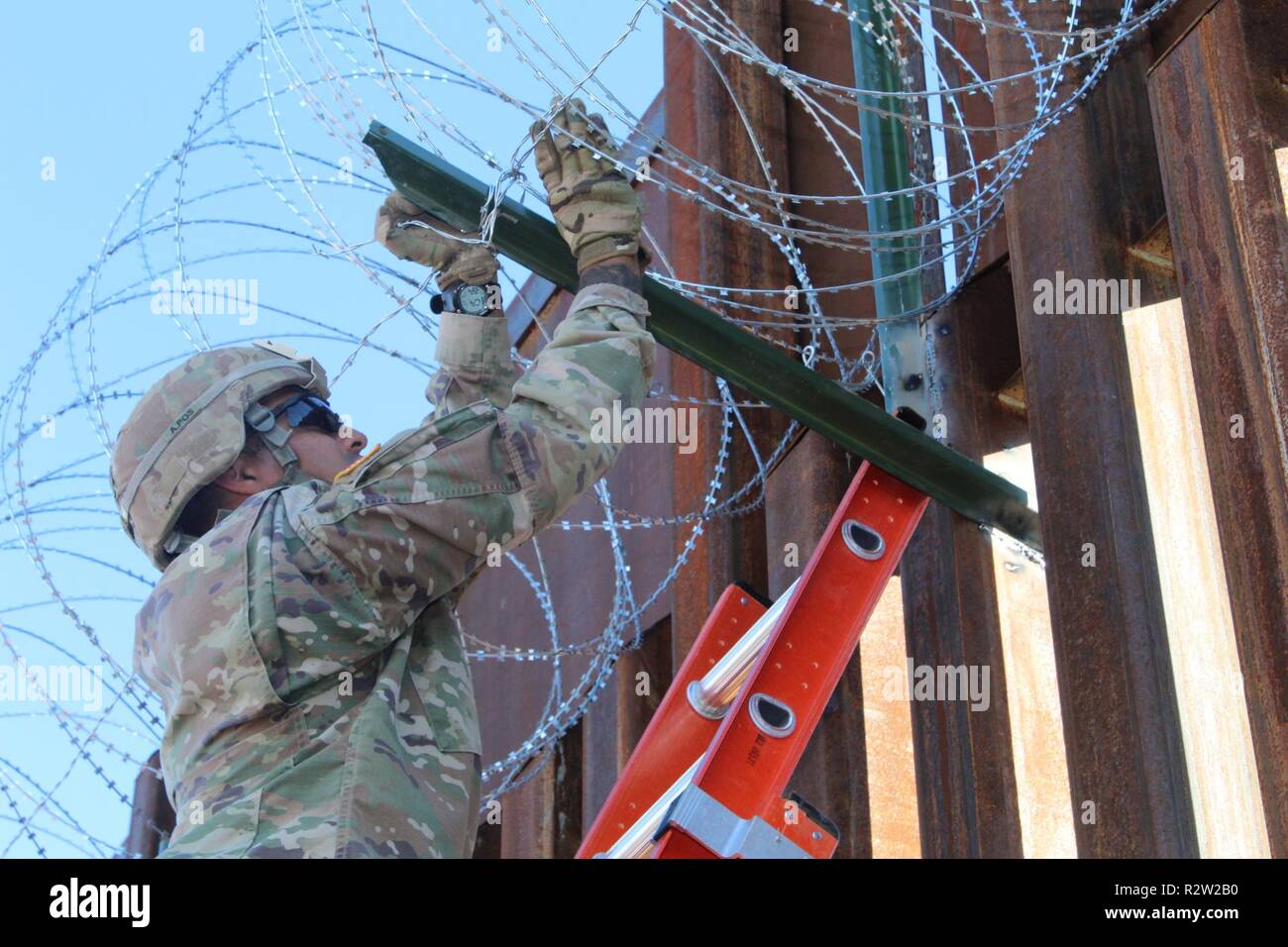 PFC Jamal Colon, 87th Sapper Company, ties concertina wire to a picket ...