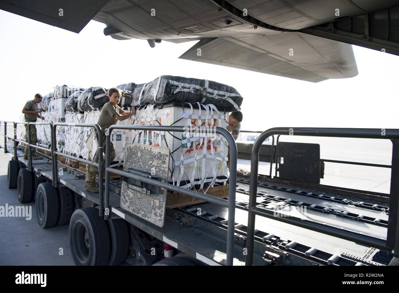 U.S. Air Force air transportation members load cargo onto a C-130H ...