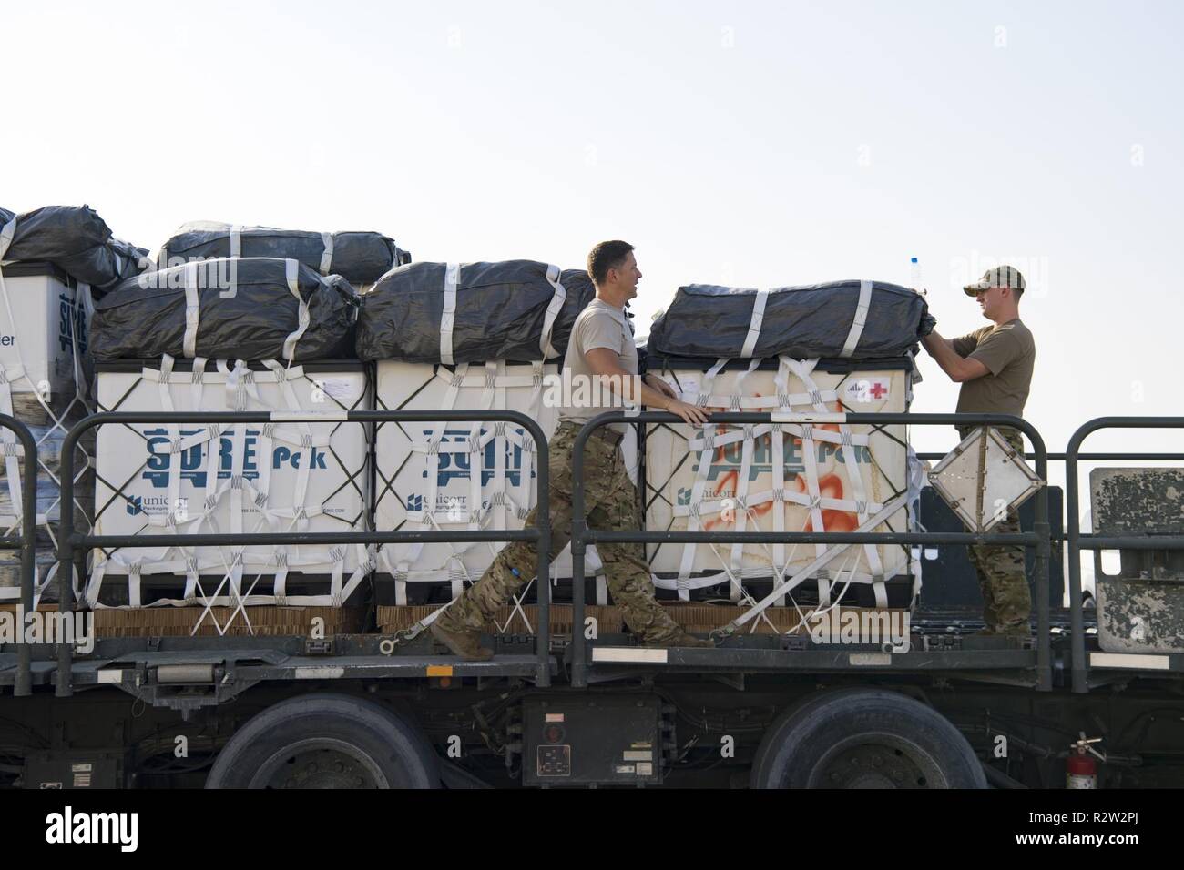 U.S. Air Force air transportation members load cargo onto a C-130H ...