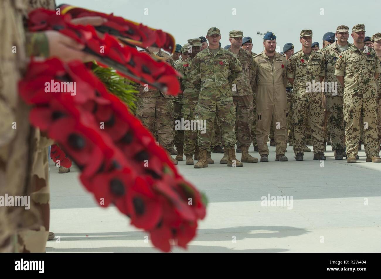 Service members stand in a multinational formation during a Service of ...