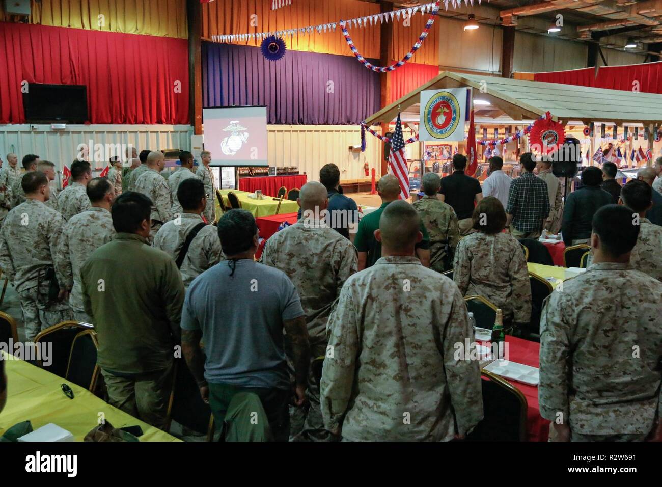 U.S. service members, coalition forces, and contractors stand during ...