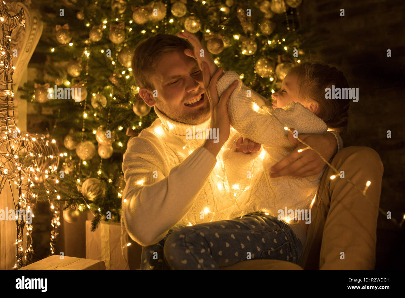 Dad and daughter fool around the Christmas tree Stock Photo - Alamy