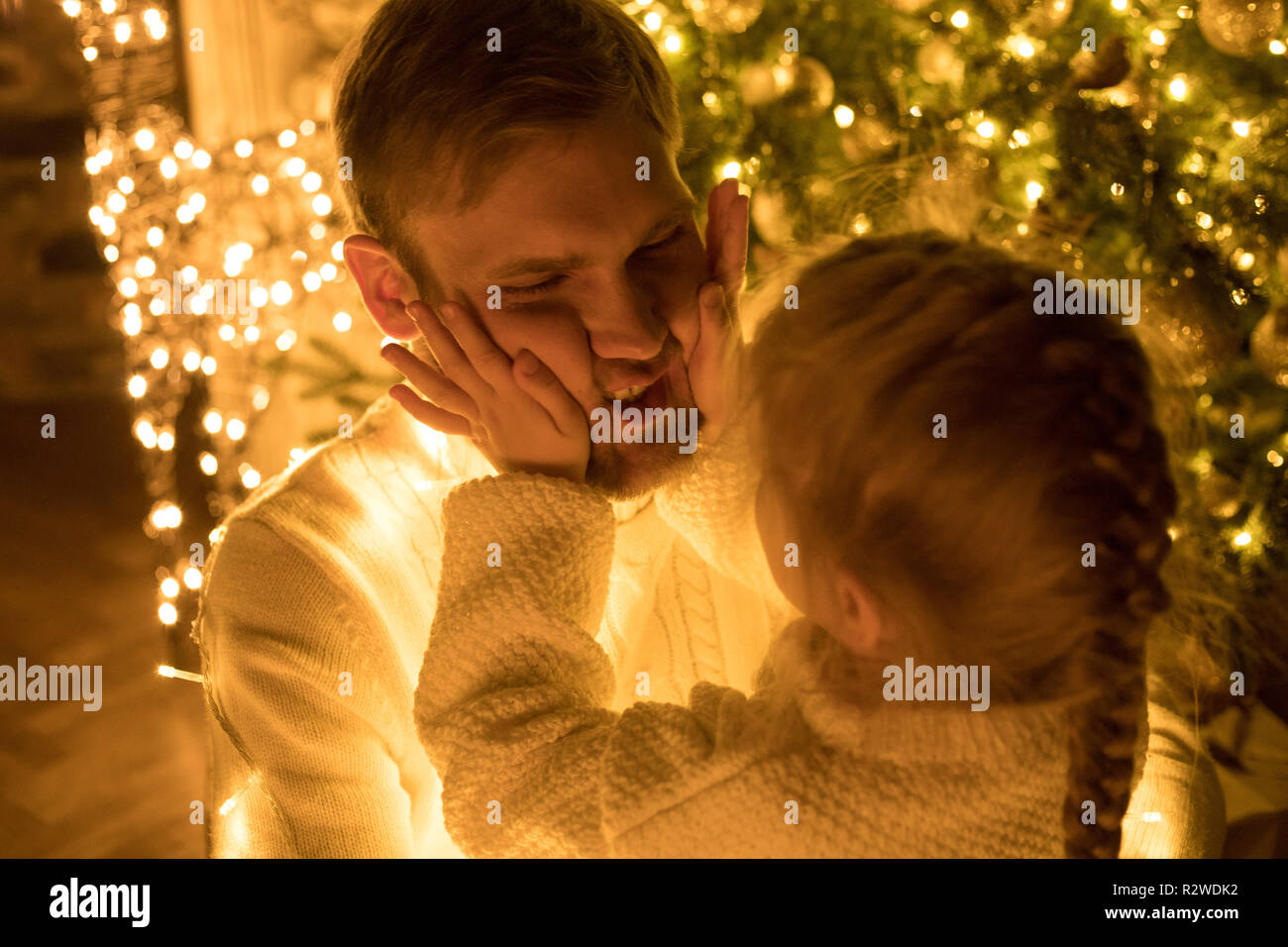 Dad and daughter fool around the Christmas tree Stock Photo - Alamy