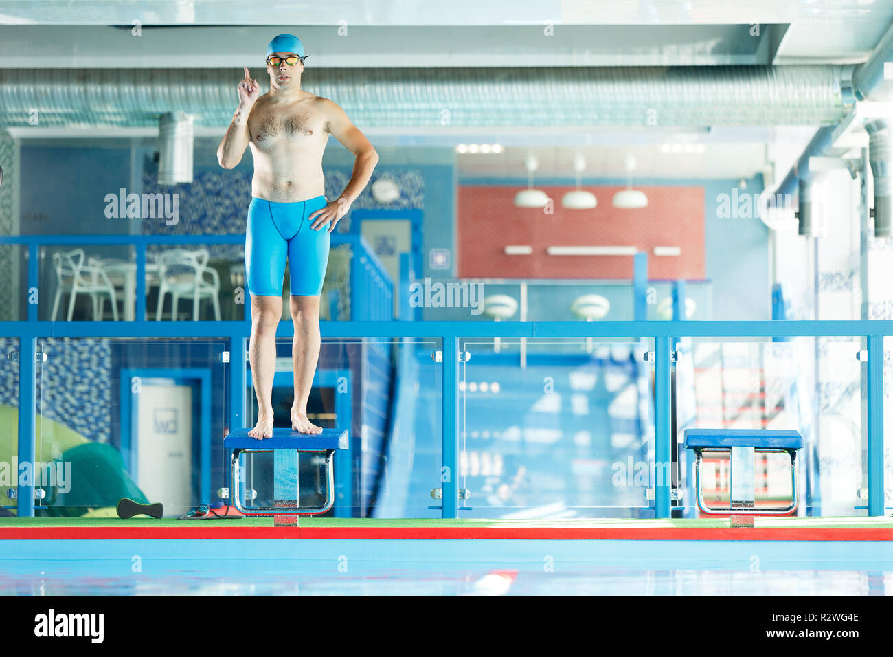 Photo of swimmer standing on ledge in pool during workout Stock Photo ...