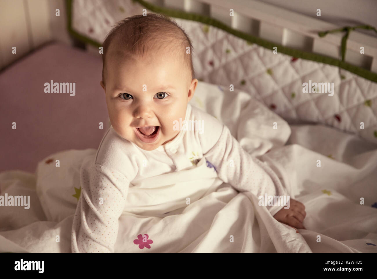 Cute baby sitting in a bed Stock Photo - Alamy