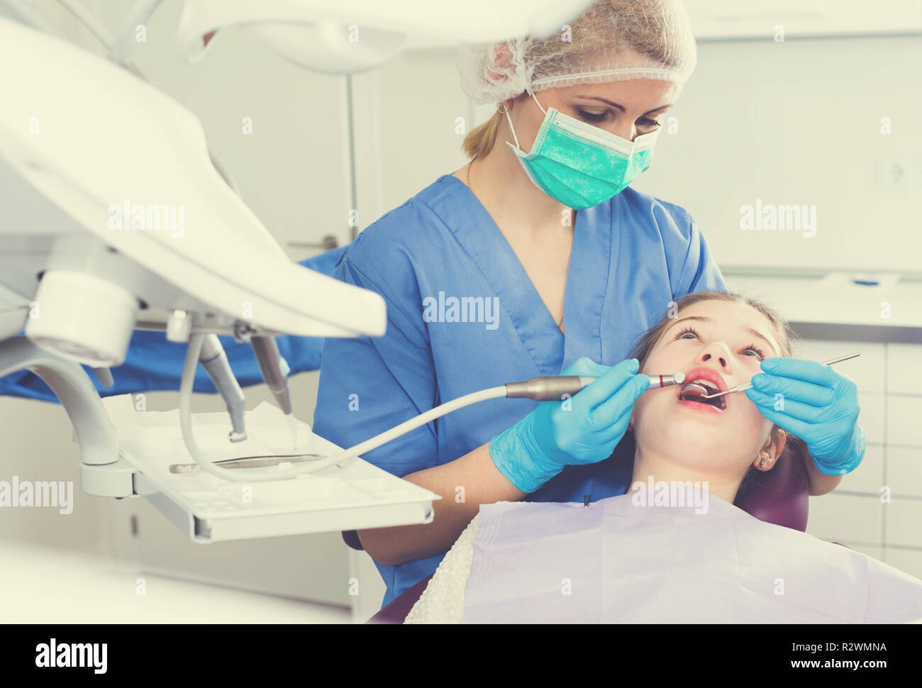 Female dentist treating teen girl patient in modern dental office Stock ...