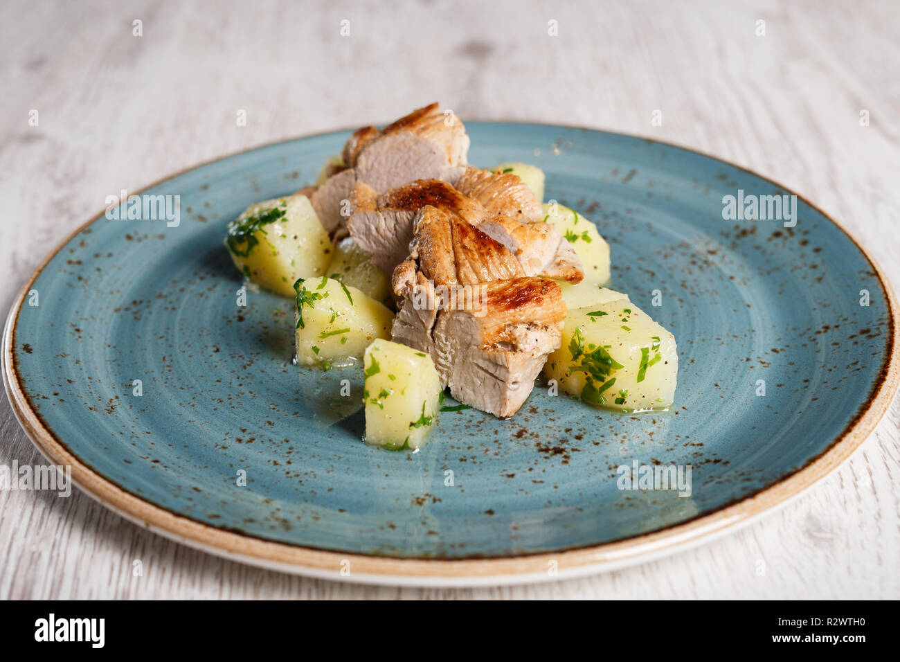 Baked pork muscle with potatoes, seasoned with parsley Stock Photo - Alamy
