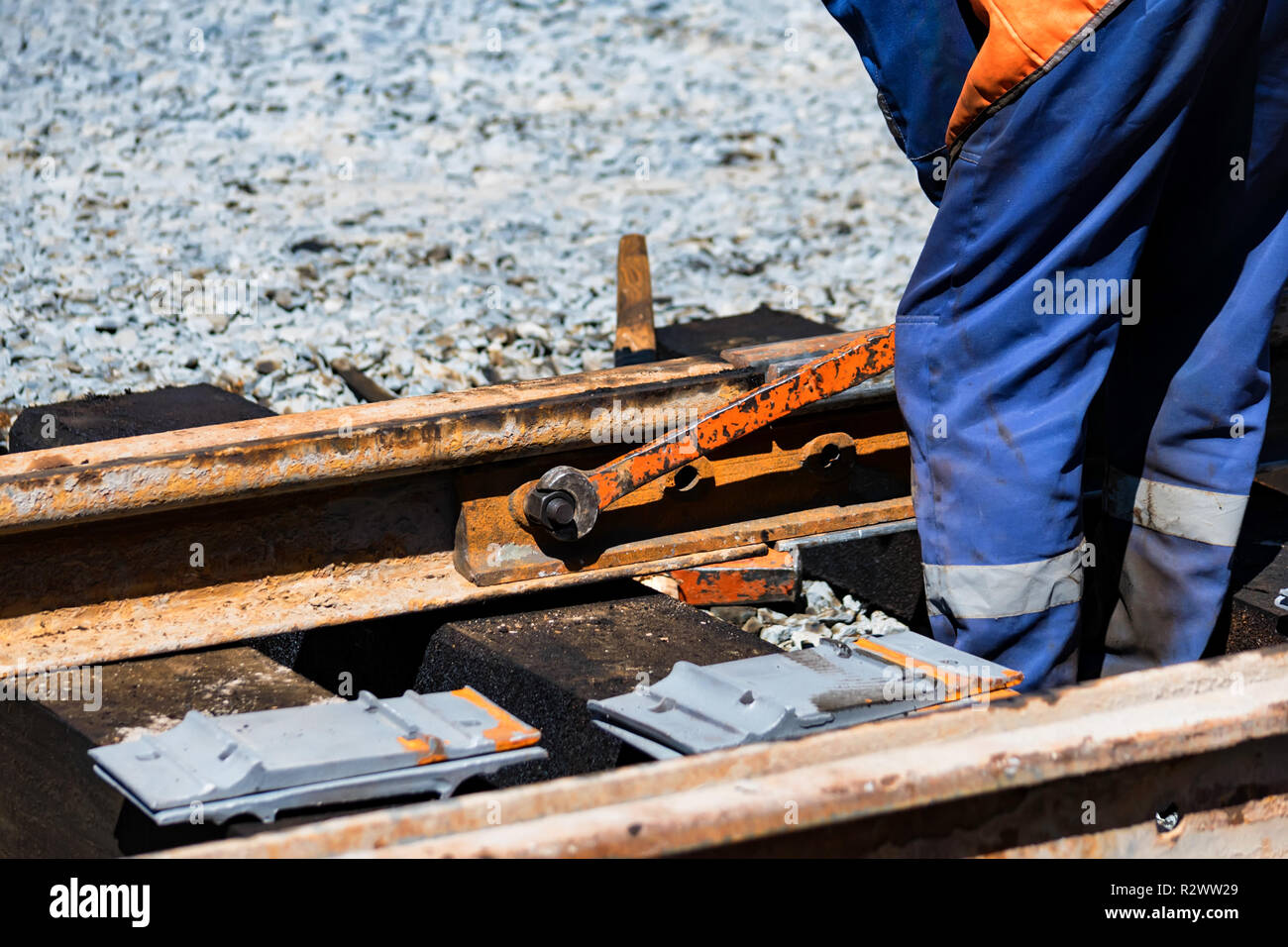 Worker tightens the skrew in railway or tram tracks Stock Photo - Alamy